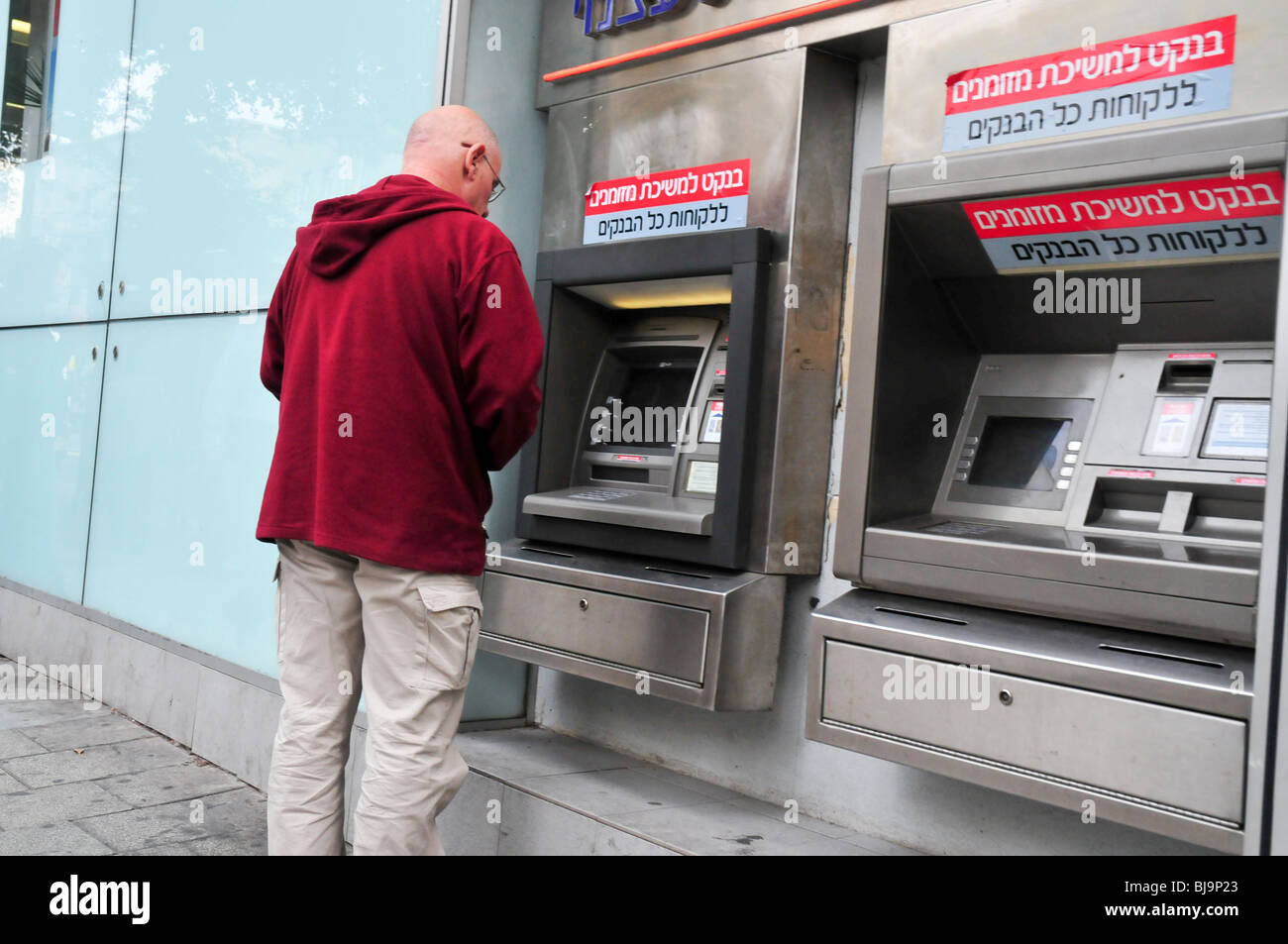 Israel, Tel Aviv, Allenby street, Man withdraws money from an ATM ...