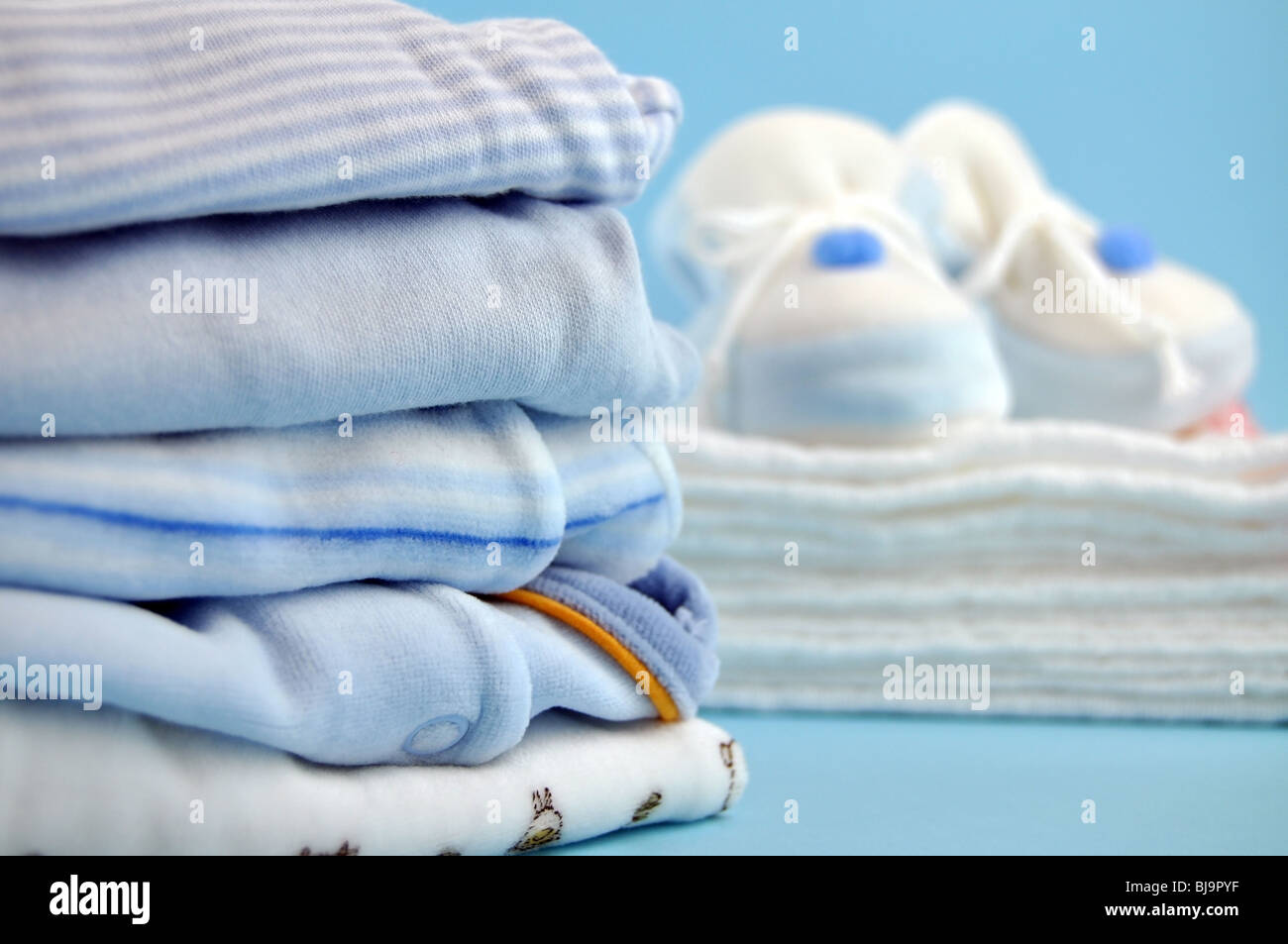 Pile of blue baby clothes and slippers on cotton diapers Stock Photo ...
