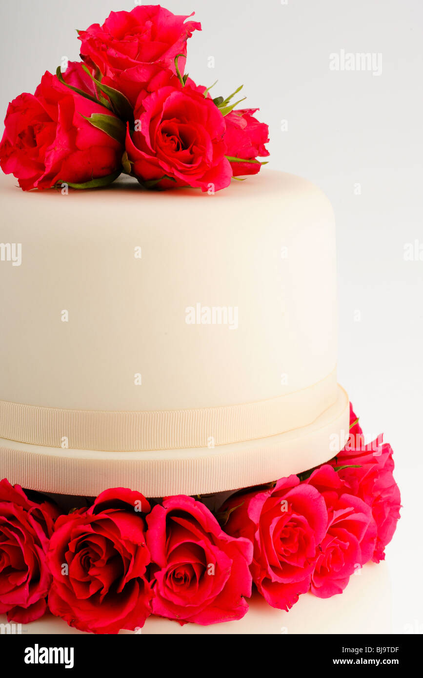 Tiered wedding cake with edible red roses Stock Photo - Alamy