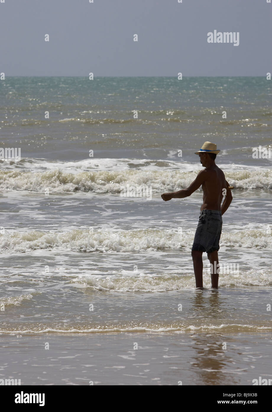 Brazilian man fishing on beach Stock Photo - Alamy
