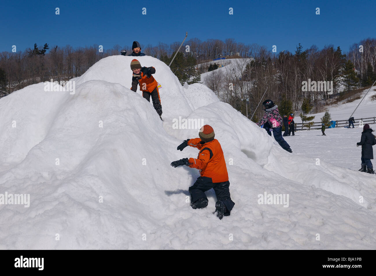 Playing children having a snow fight on a snow Castle at Lakeridge ski ...