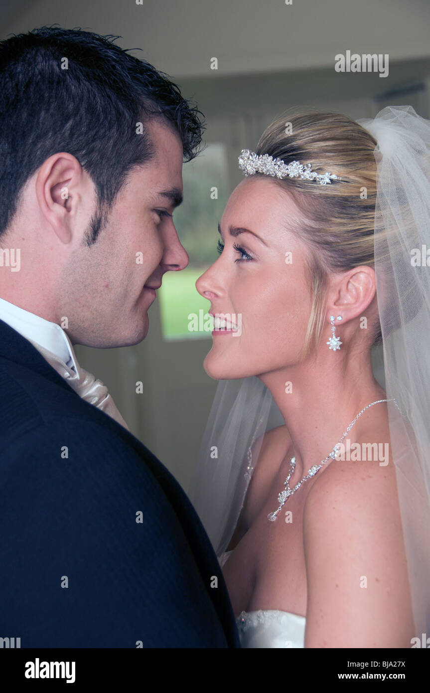 Good looking bride and groom on their wedding day smiling and looking ...