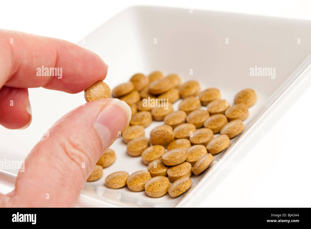taking a pill from a bowl of pills Stock Photo - Alamy