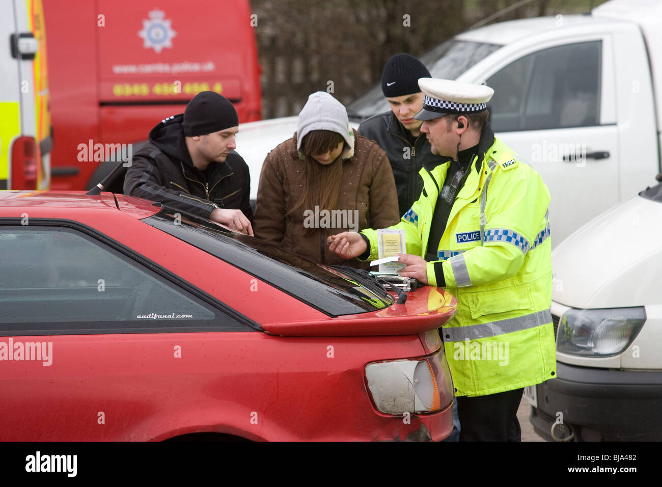 A police officer checking and talking to foreign car drivers at joint ...