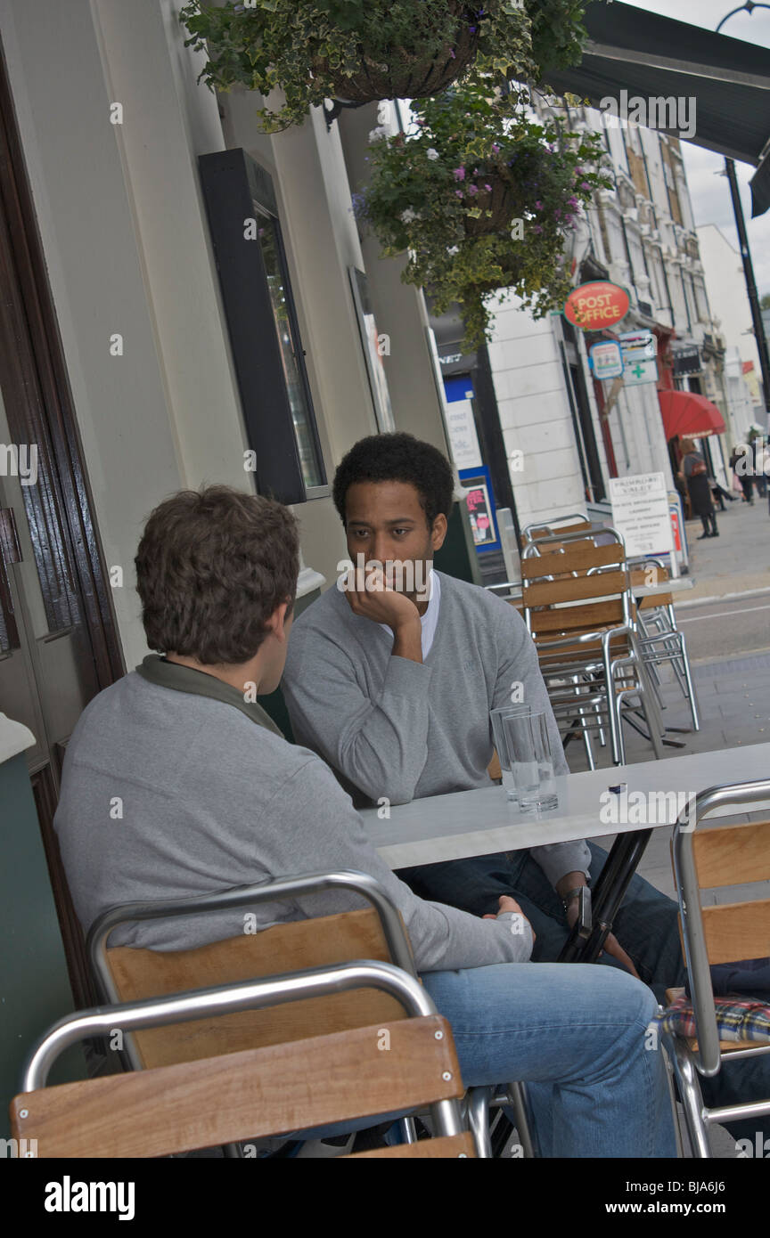 Two men chat outside a primrose hill cafe in London Stock Photo - Alamy