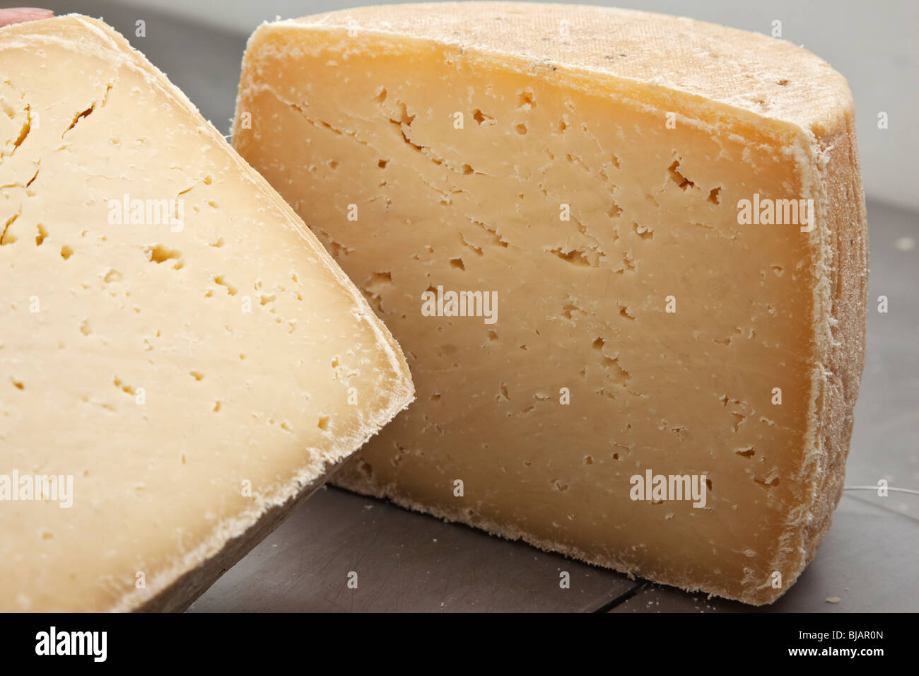 Whole cheese cut into two halves Stock Photo - Alamy