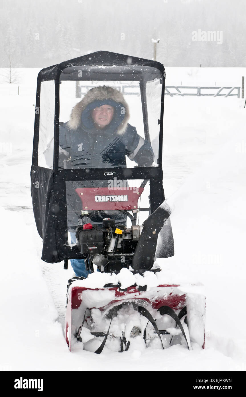 Man (male) using push Craftsman snow blower during heavy snow storm ...