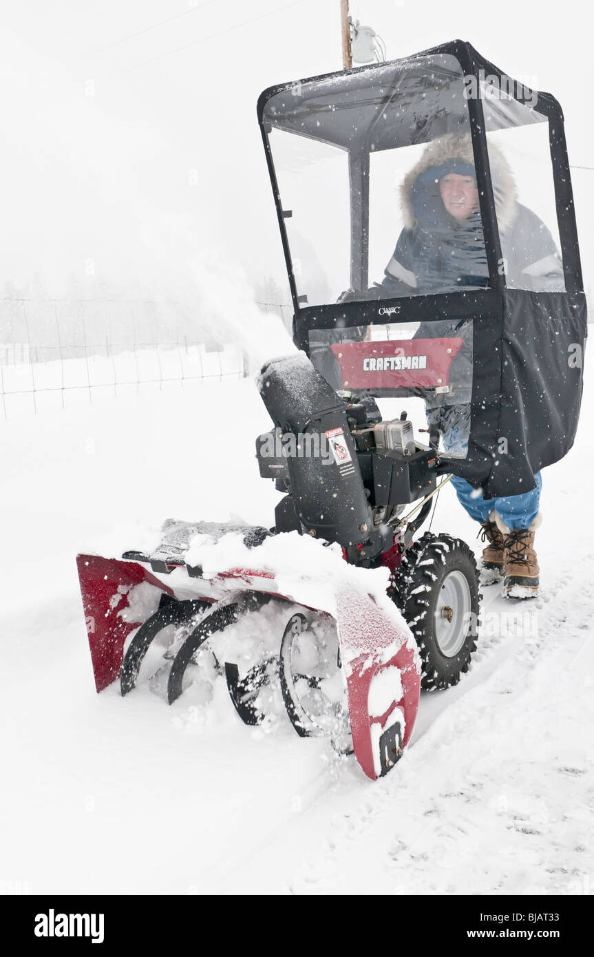 Man (male) using push Craftsman snow blower during heavy snow storm ...