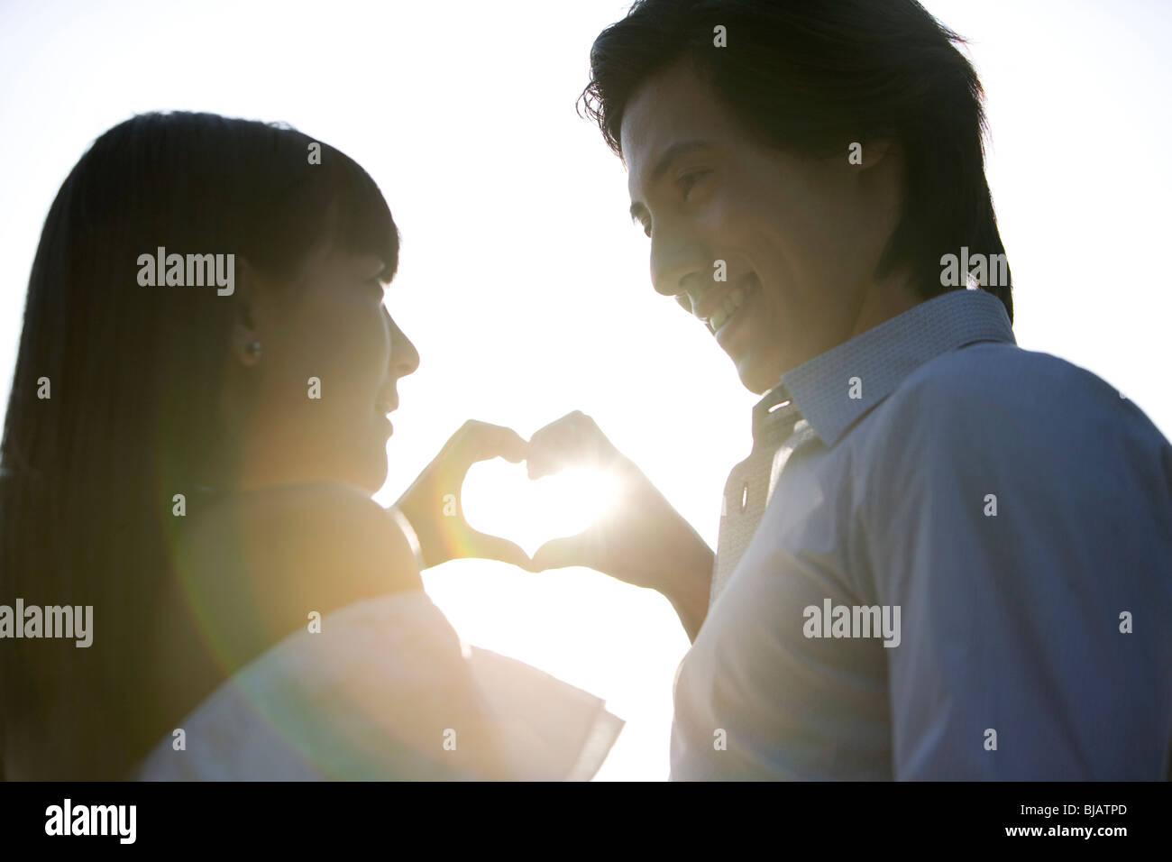 Young couple making a heart shape Stock Photo - Alamy