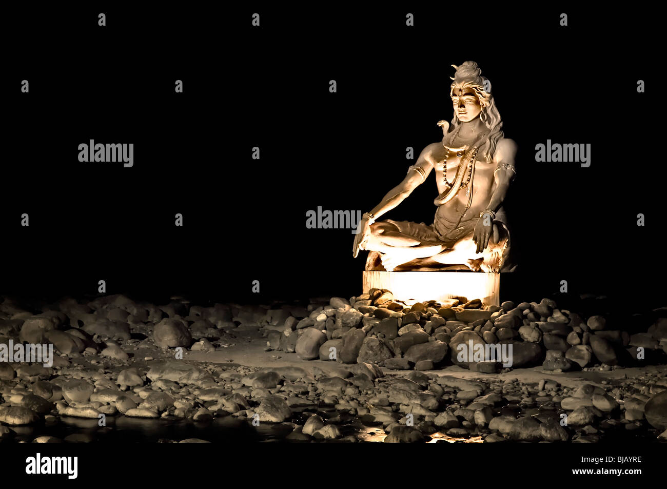 Statue of Shiva seated in meditative repose in the Ganga / Ganges River ...