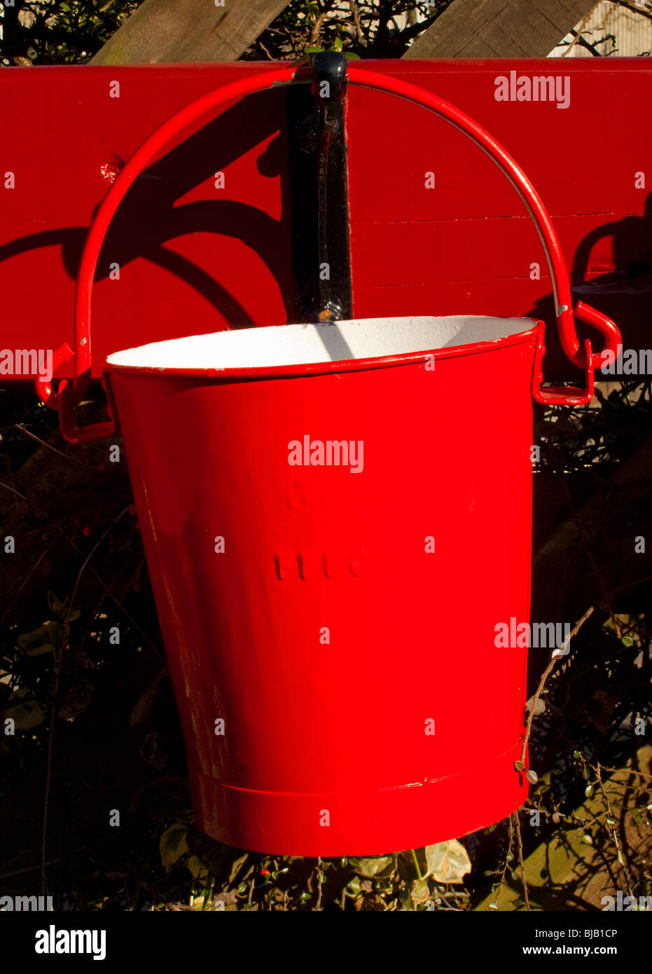 Bright red painted fire buckets hanging on a wooden fence Stock Photo ...
