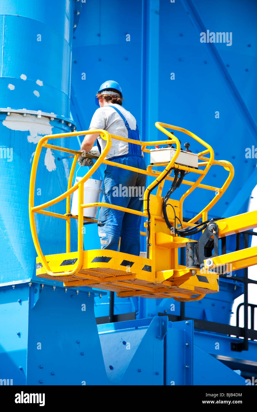 Construction worker in cherry picker working on industrial plant Stock ...