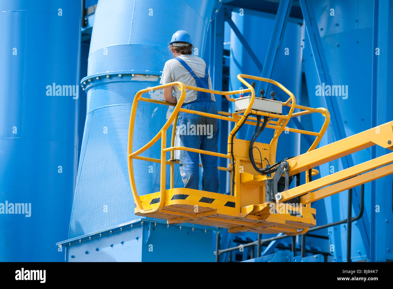 Painter painting industrial pipe from a cherry picker Stock Photo - Alamy