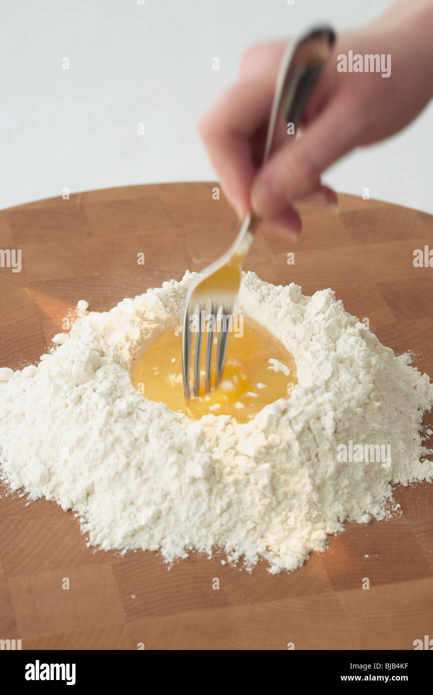 Hand mixing fresh pasta ingredients with a fork Stock Photo - Alamy