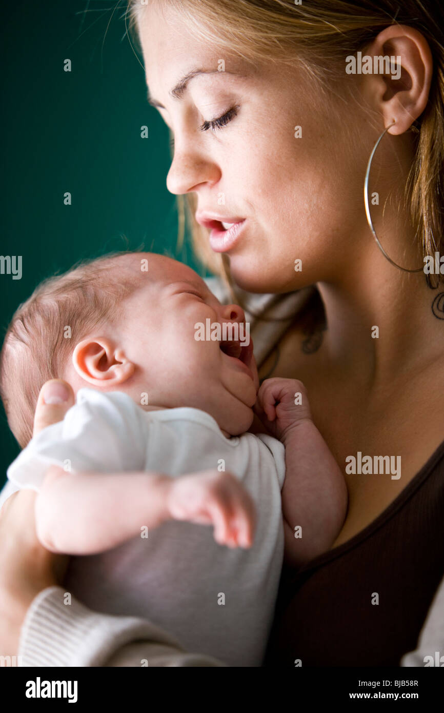 Mother comforting crying newborn baby Stock Photo - Alamy