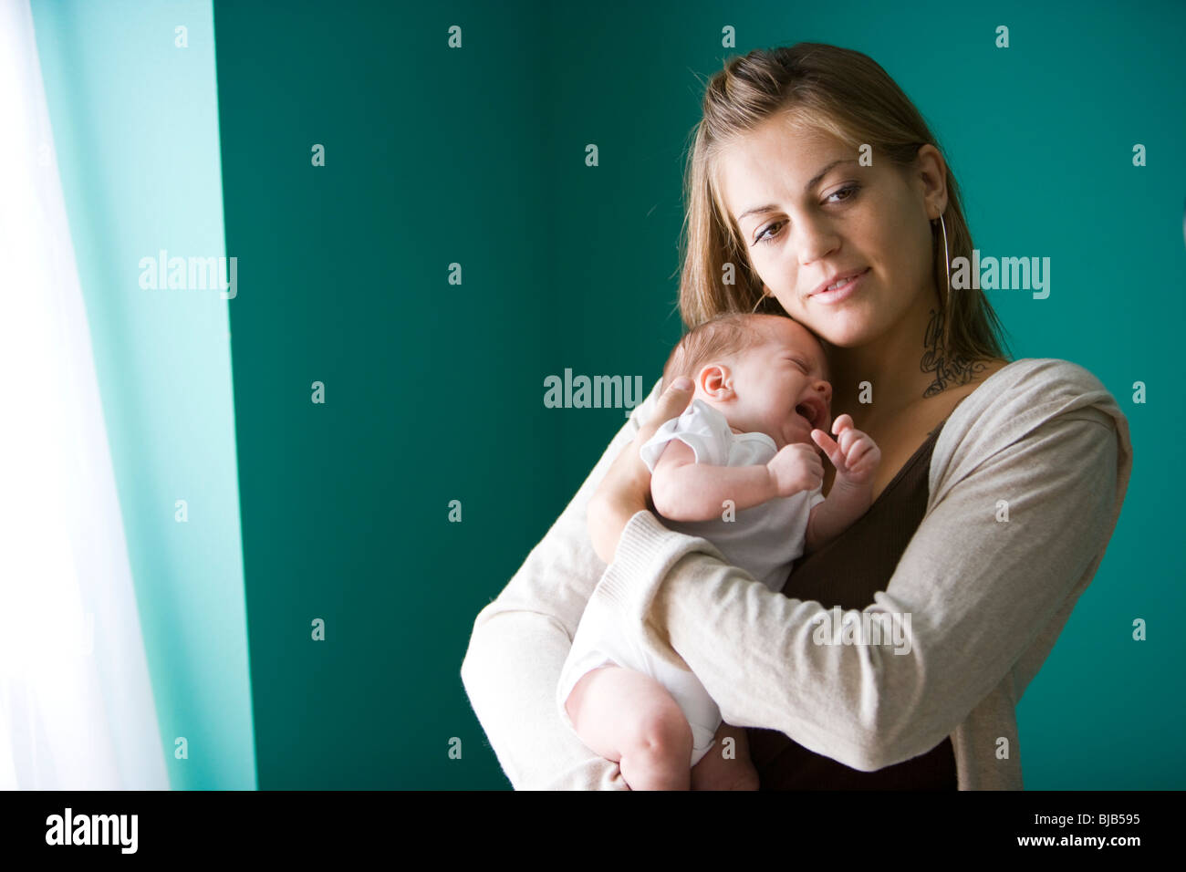 Mother comforting crying newborn baby Stock Photo - Alamy