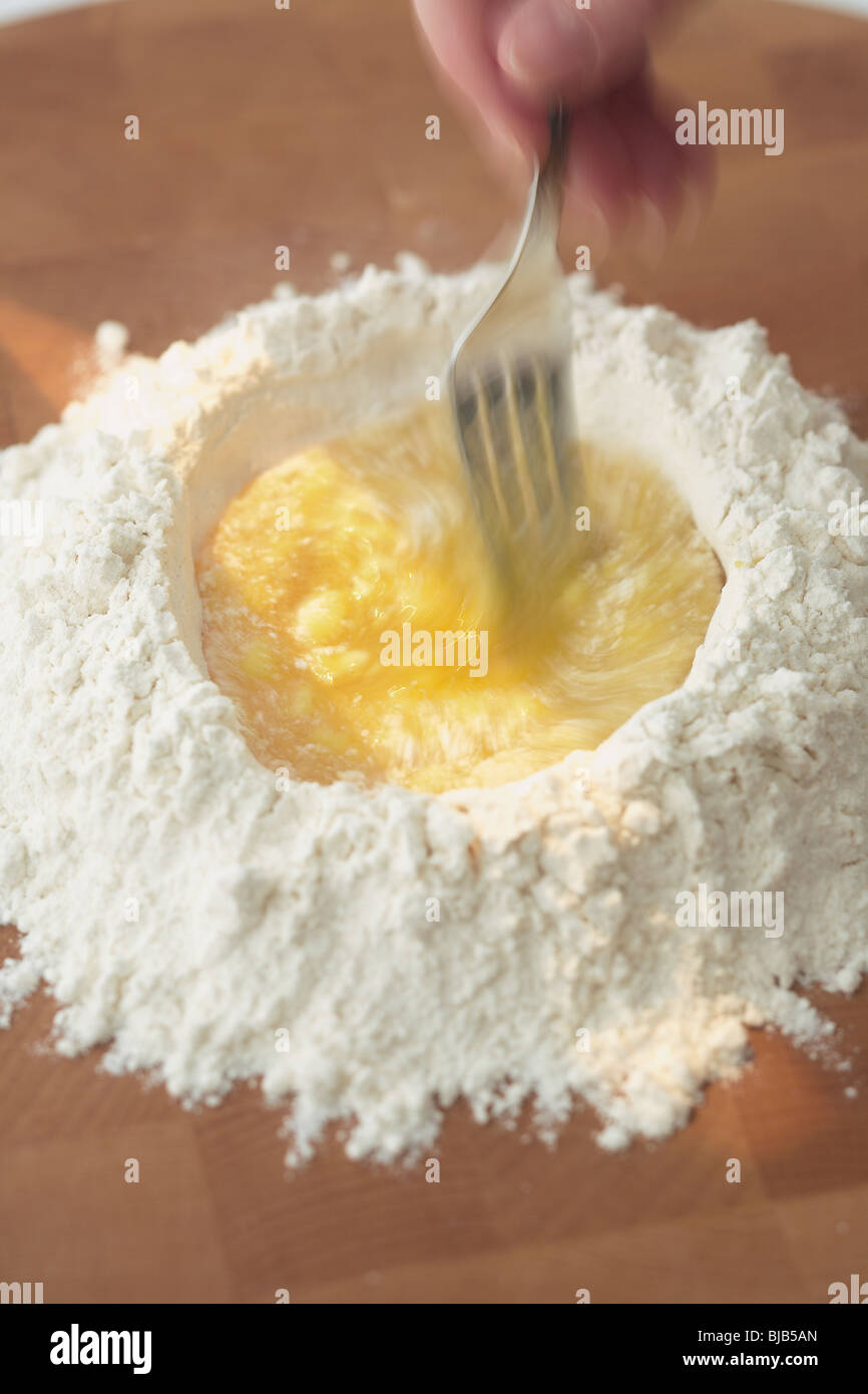 Hand mixing fresh pasta ingredients with a fork Stock Photo - Alamy