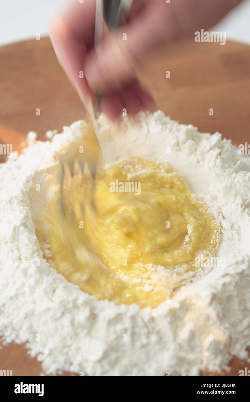 Hand mixing fresh pasta ingredients with a fork Stock Photo - Alamy