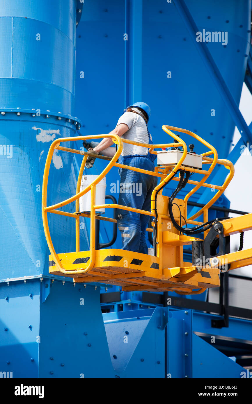 Construction worker in cherry picker working on industrial plant Stock ...