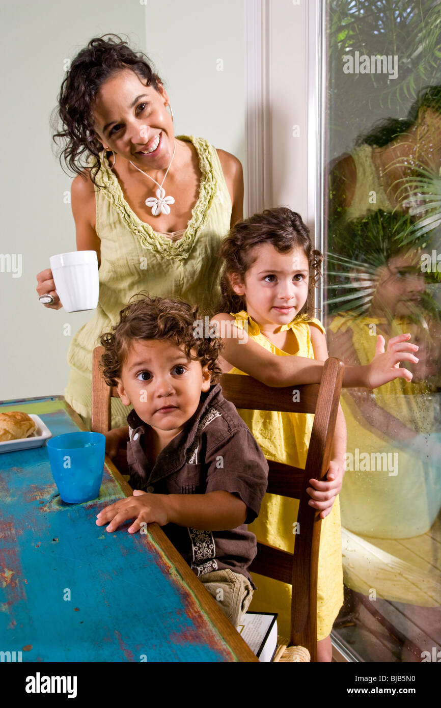 Hispanic mother with children at dining table at home Stock Photo - Alamy