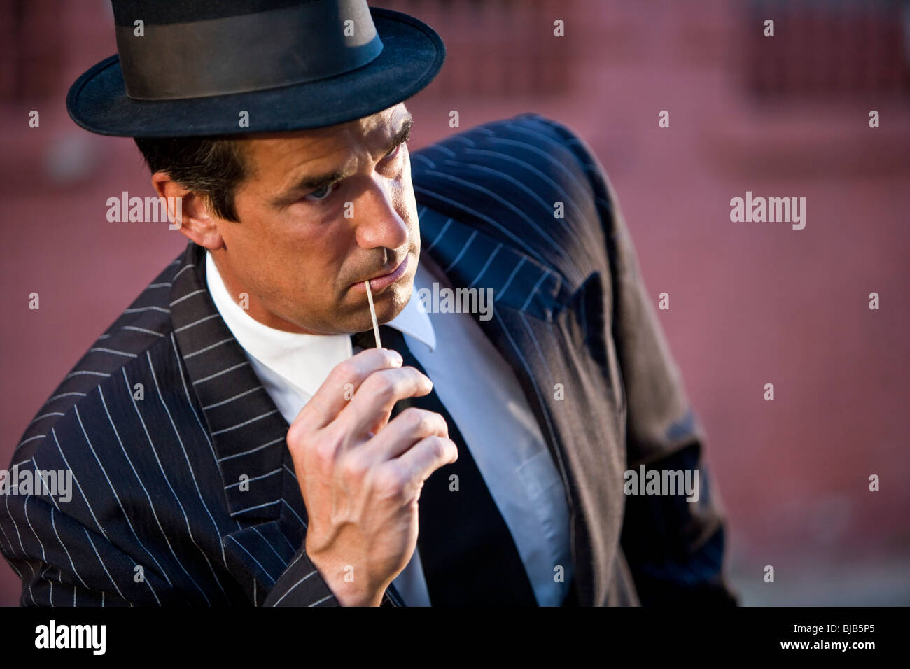 Serious man wearing pinstripe suit with toothpick Stock Photo - Alamy