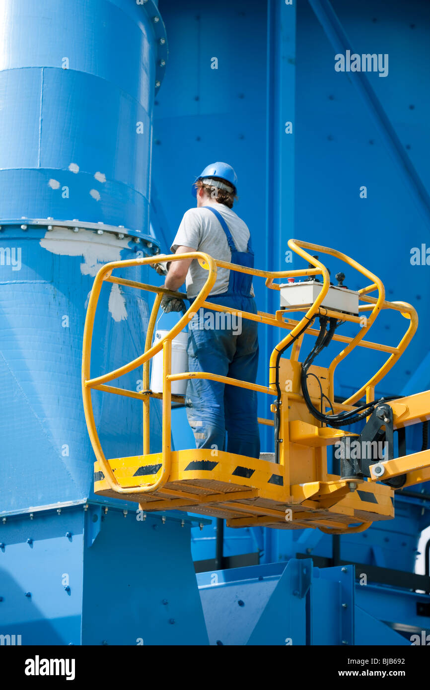 Construction worker in cherry picker working on industrial plant Stock ...