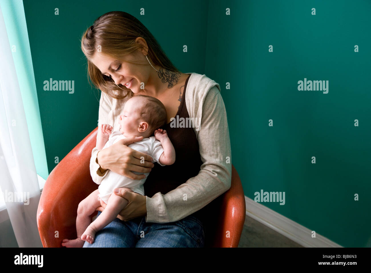 Mother holding sleeping newborn baby on lap Stock Photo - Alamy