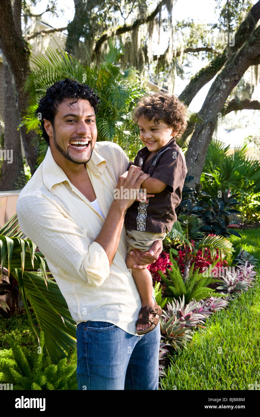 Smiling Hispanic father having fun with young son in backyard Stock ...