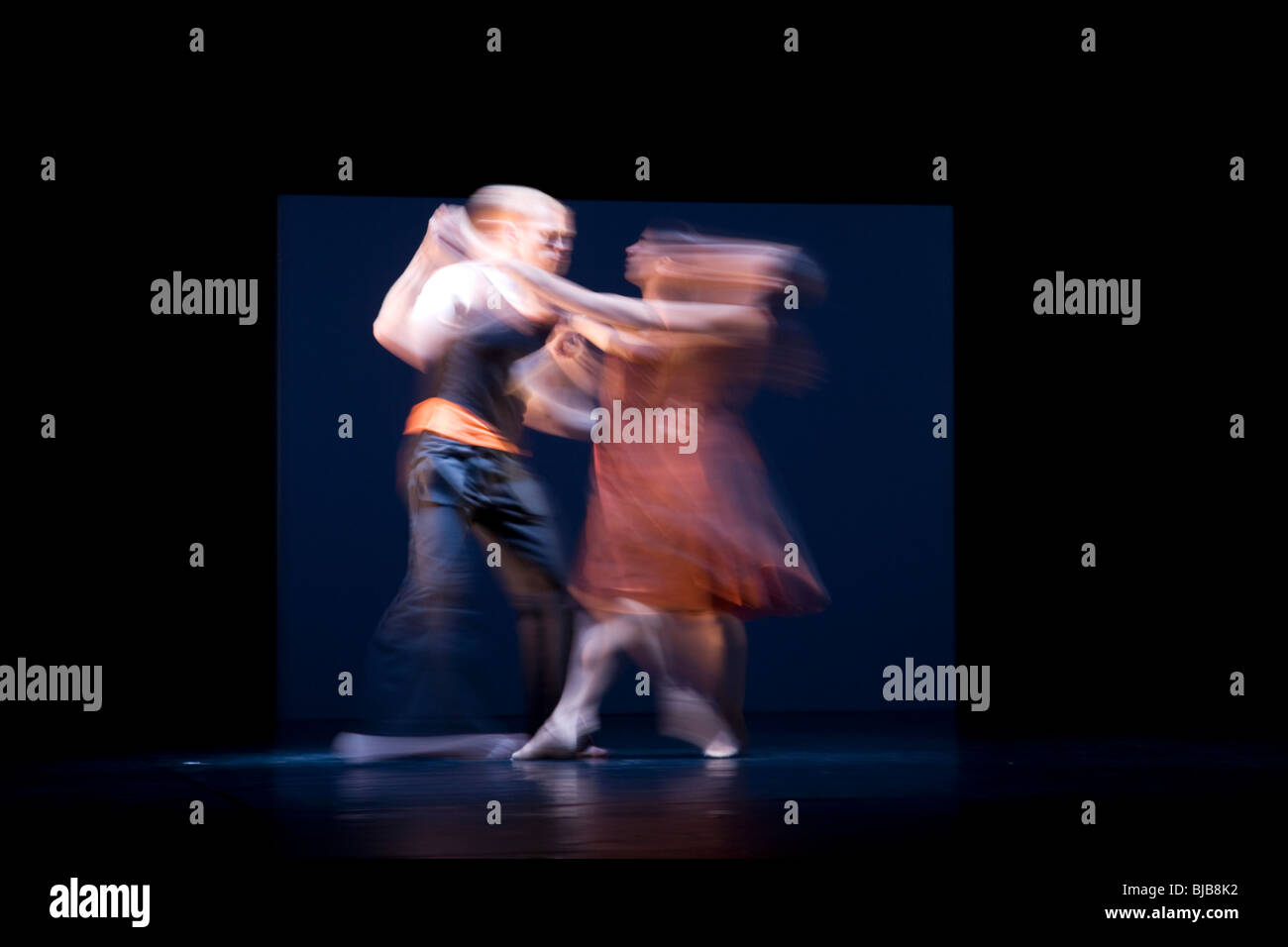 Two dancers captured in blurred movement in a modern ballet production ...