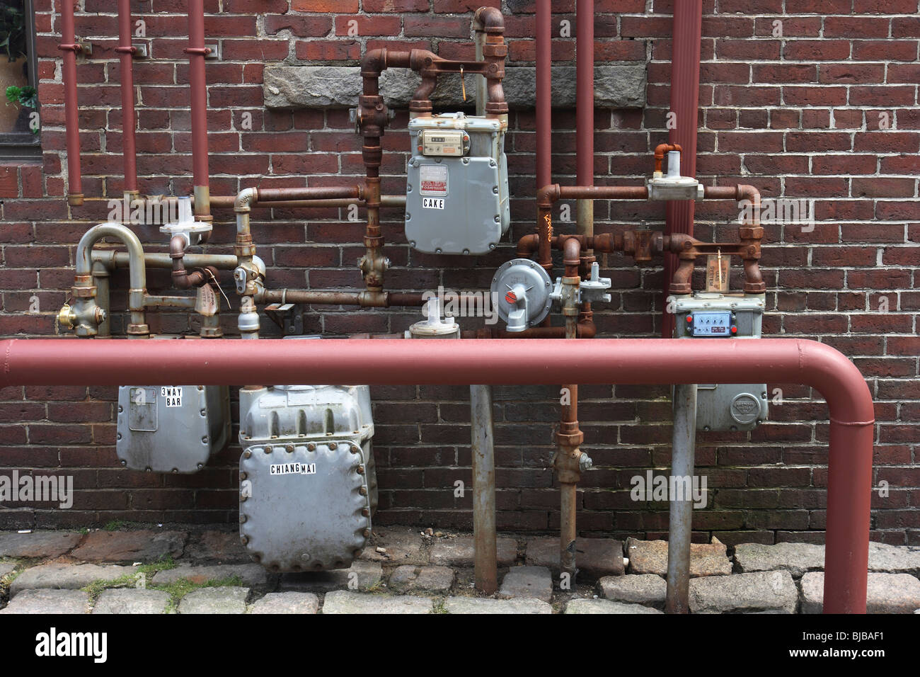 Tubes and valves on a brick wall Stock Photo - Alamy
