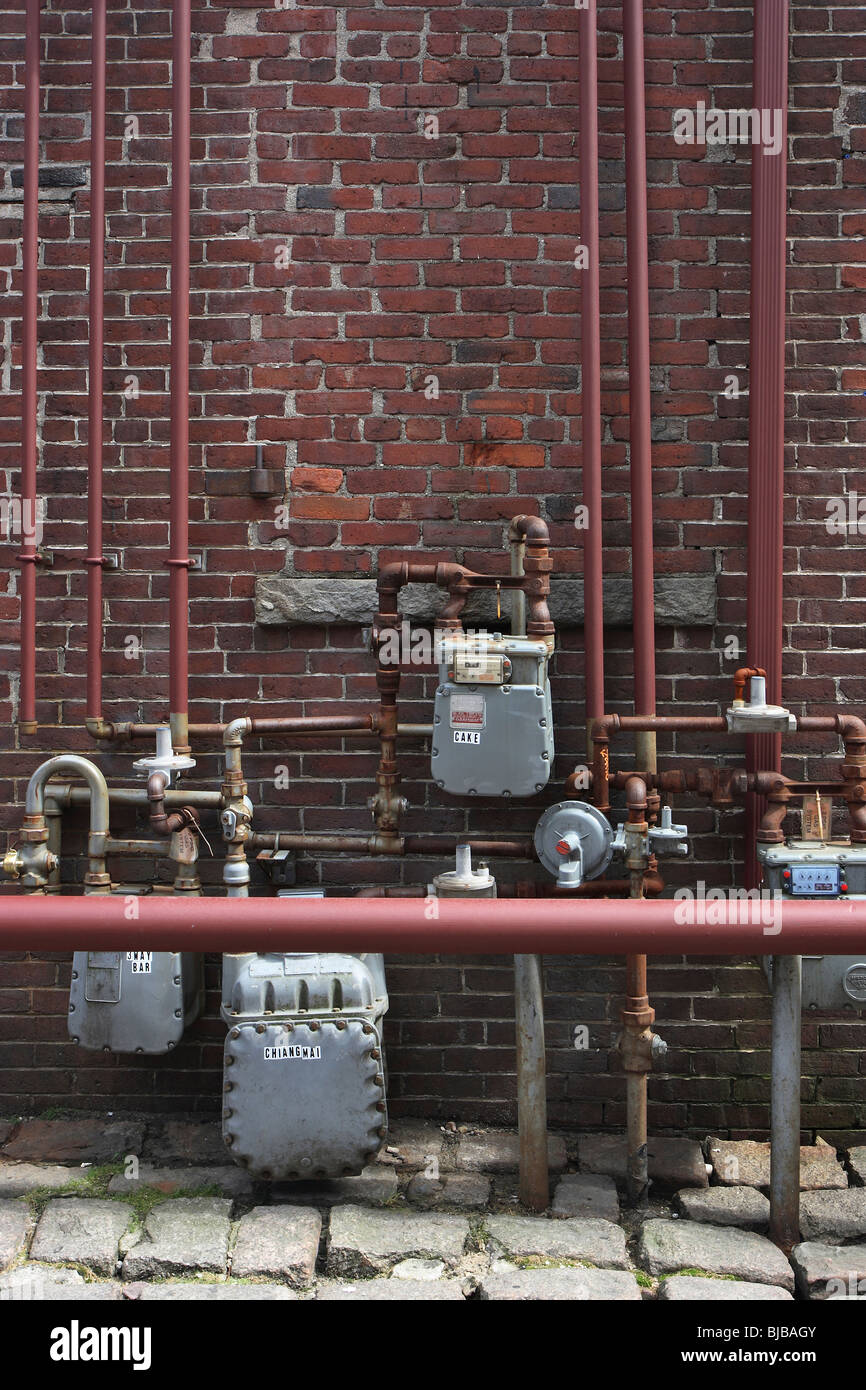Tubes and valves on a brick wall Stock Photo - Alamy