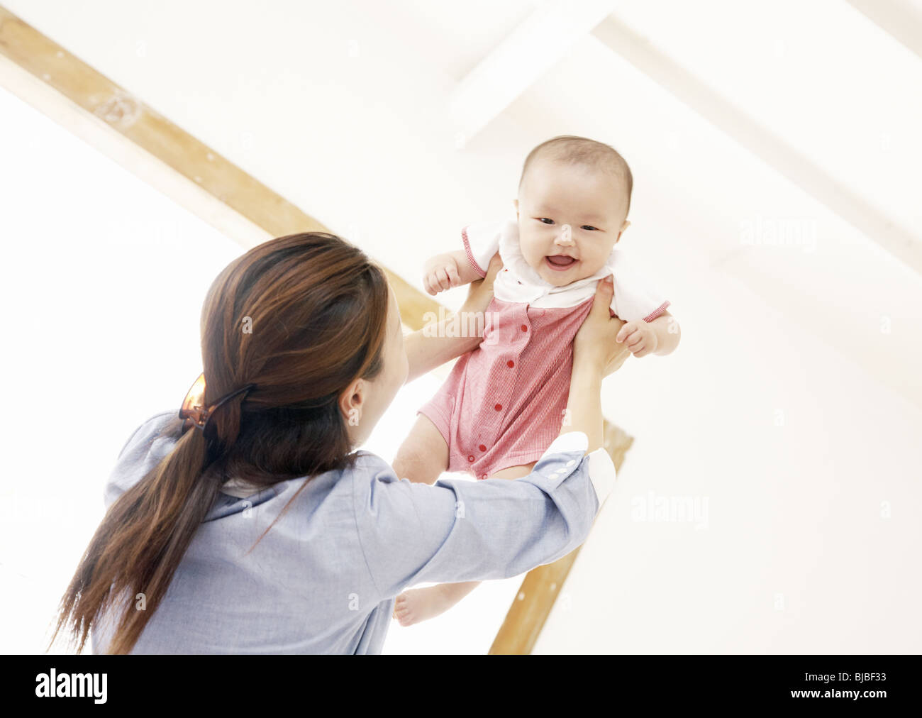 Mother taking baby up Stock Photo - Alamy