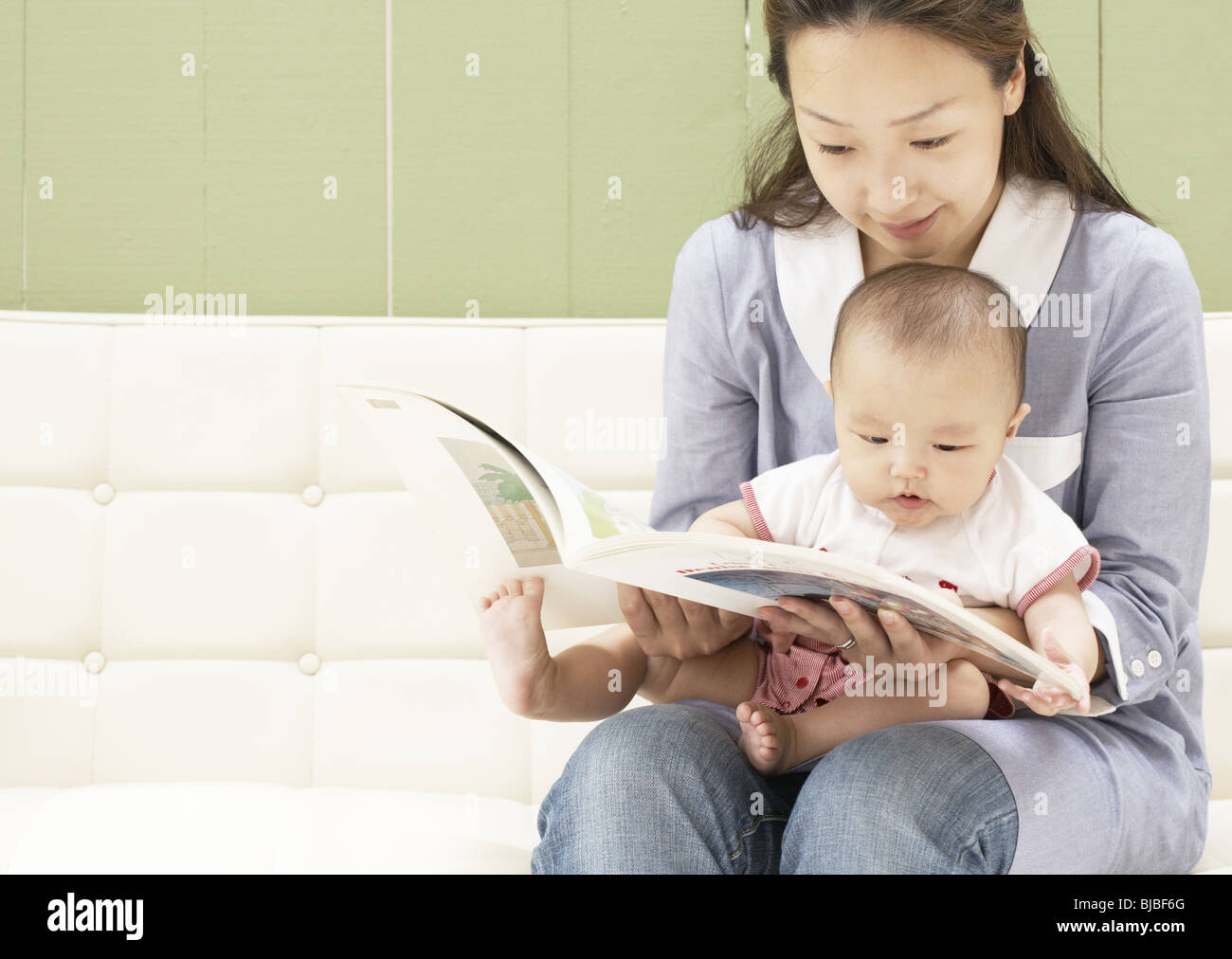 Parent and child reading a book Stock Photo - Alamy