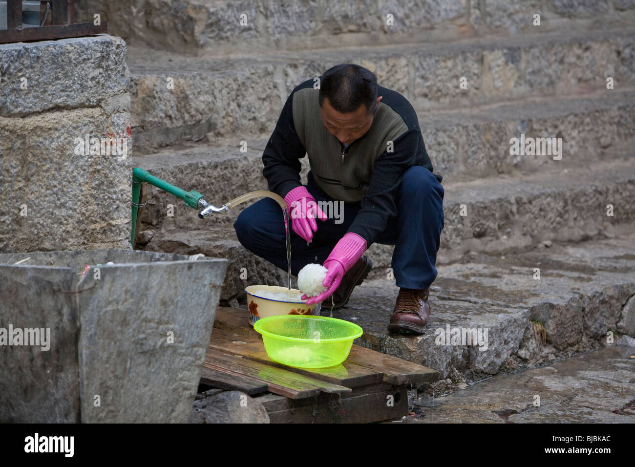 Local man washing rice in the street. Shangri La, China Stock Photo - Alamy