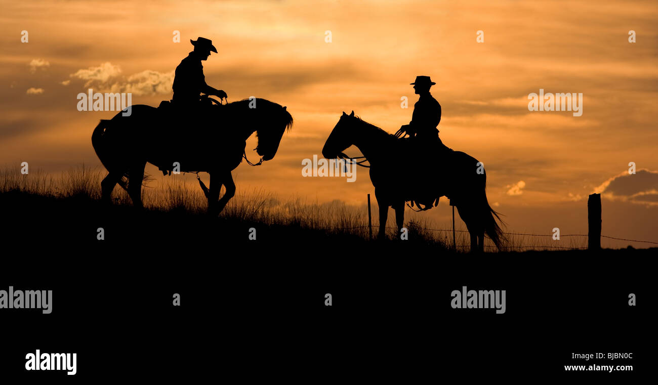 Silhouettes of cowboys meeting at sunset Stock Photo - Alamy