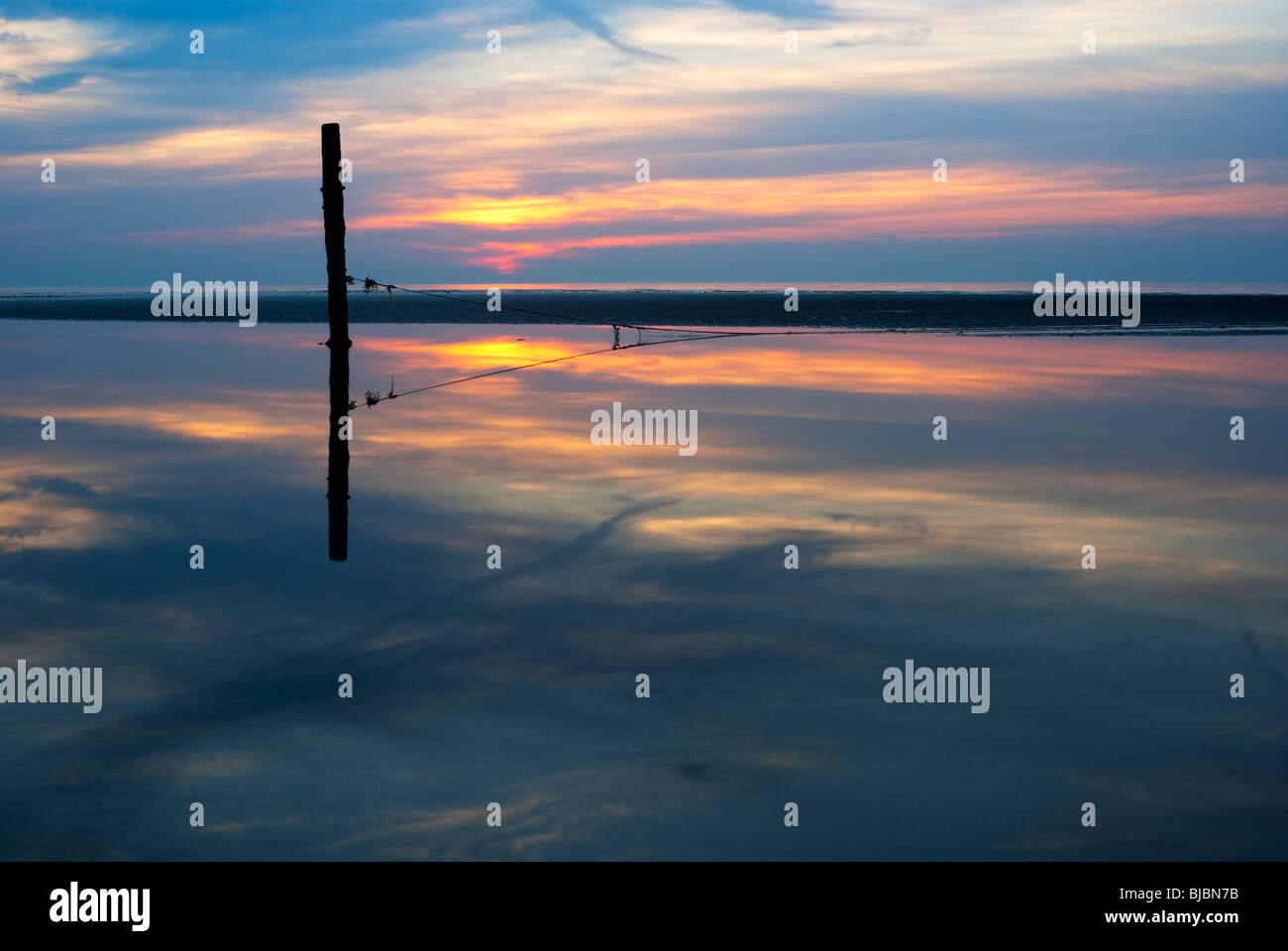 Tidal Reflections of the Sun Setting at Formby Point Stock Photo - Alamy