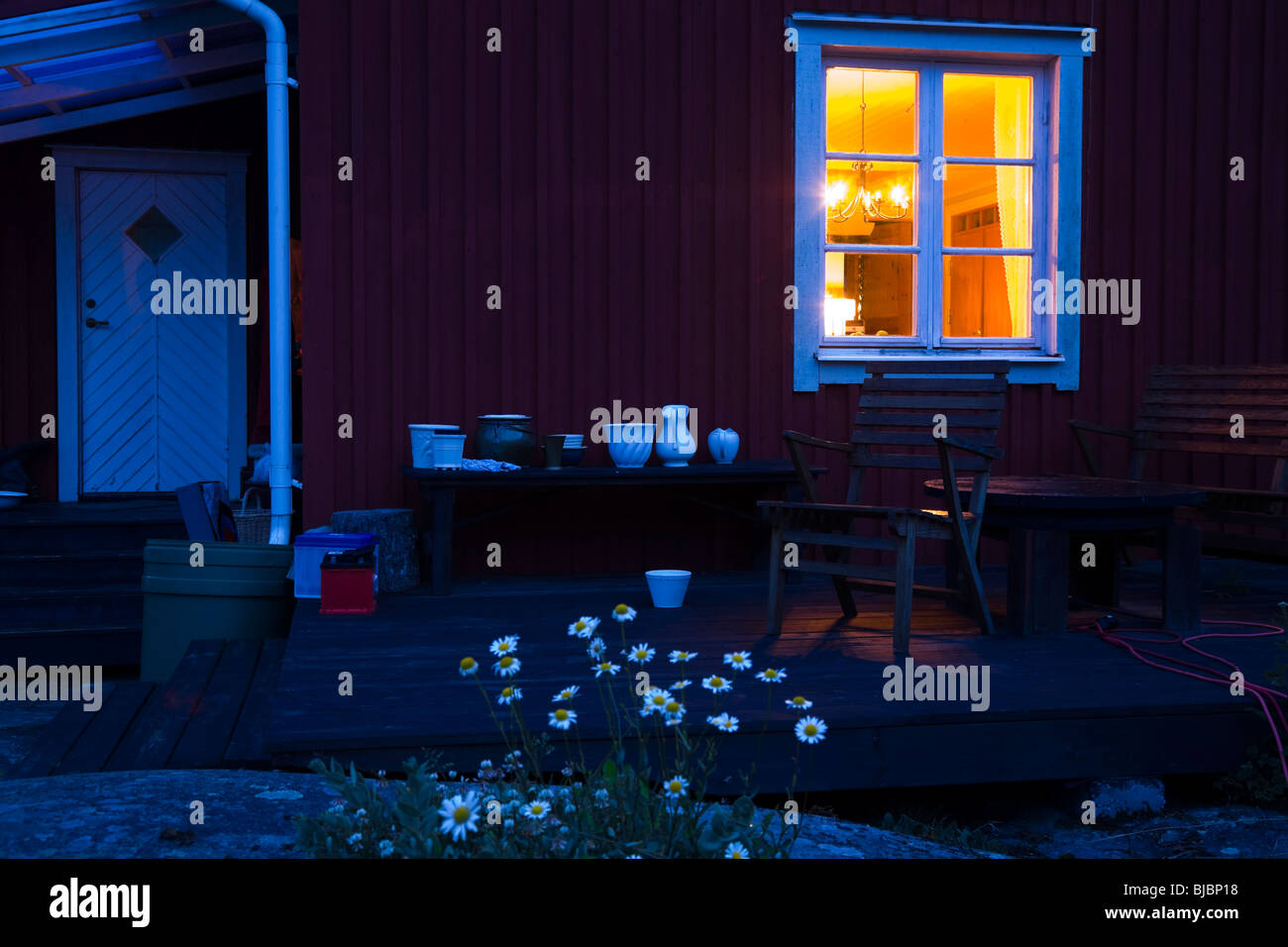 Blue summer night with yellow light from a window Stock Photo - Alamy