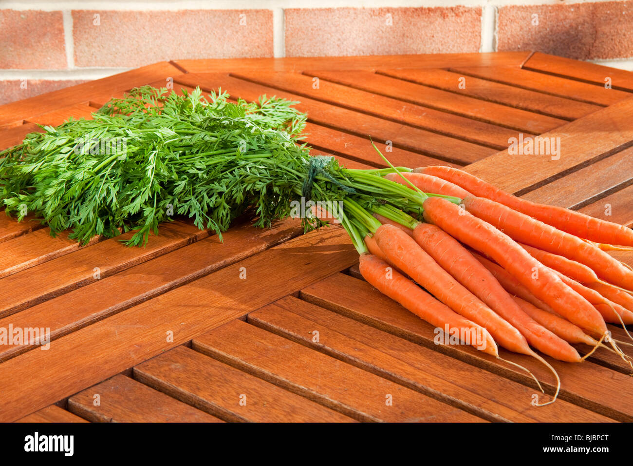 a bunch of fresh carrots on a table Stock Photo - Alamy