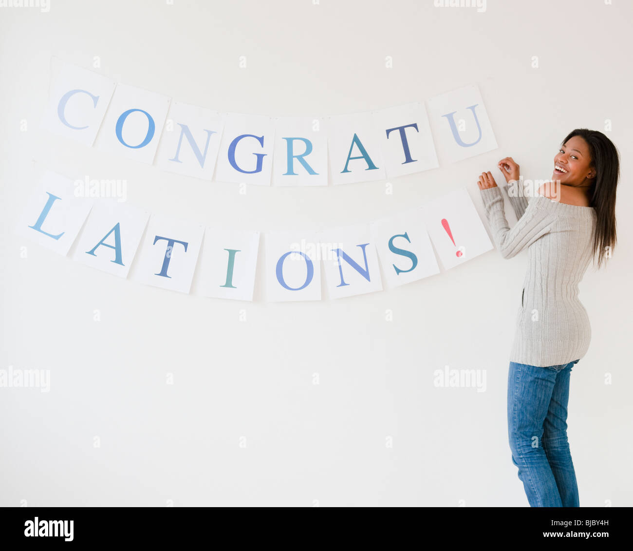 Mixed race woman putting up congratulations sign Stock Photo - Alamy