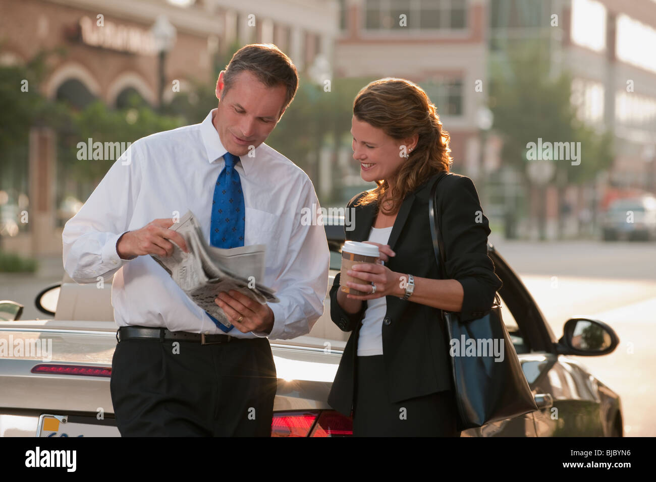 Caucasian business people looking at newspaper Stock Photo - Alamy