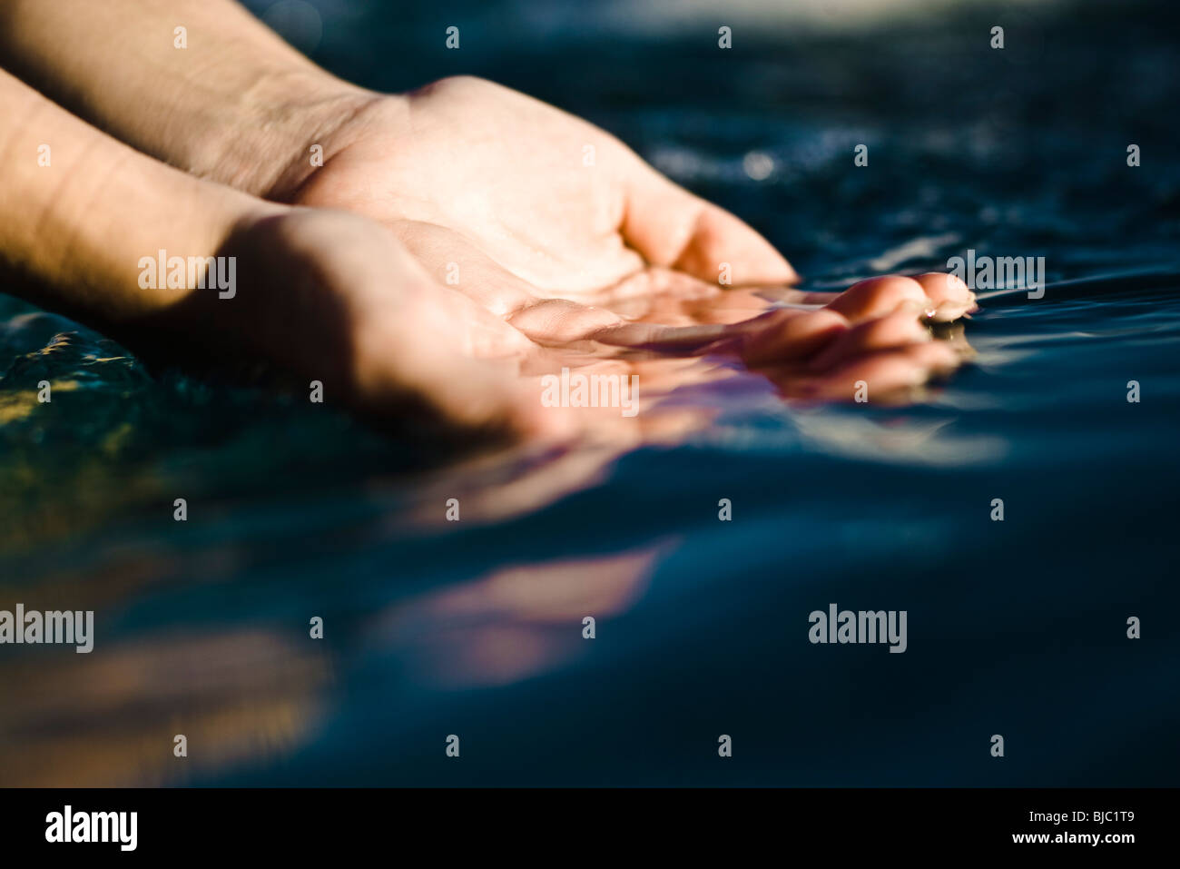 Cupped hands catching water Stock Photo - Alamy