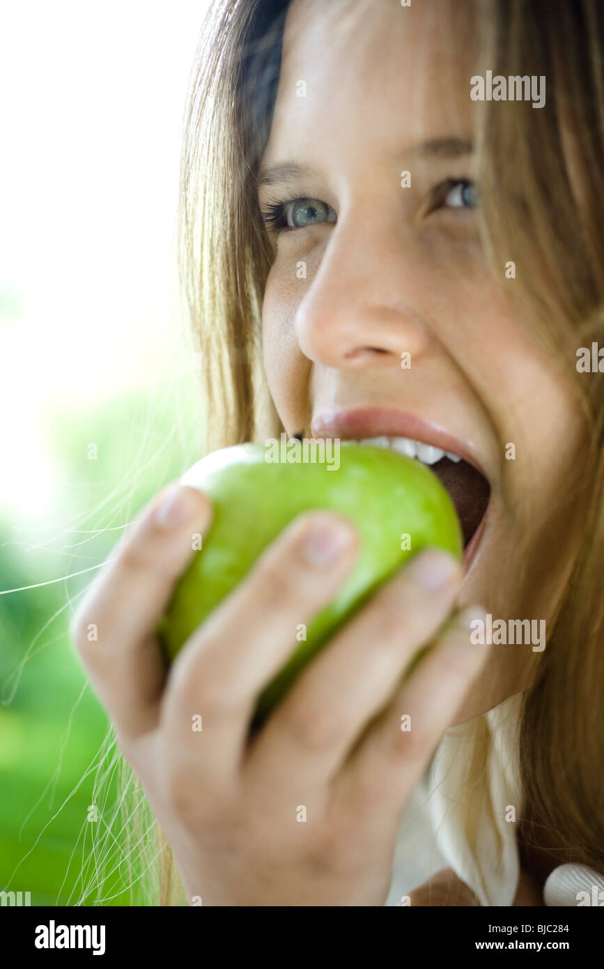 Young woman eating green apple Stock Photo - Alamy