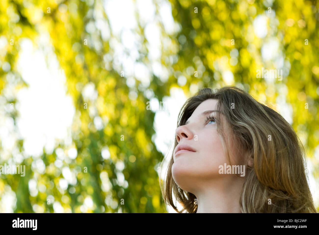 Young woman outdoors, looking up, portrait Stock Photo - Alamy