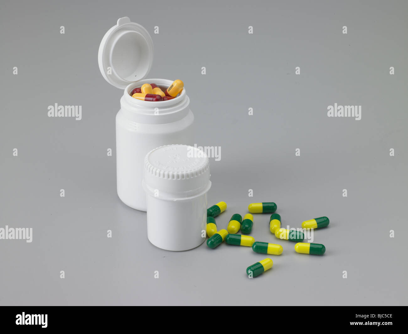 Tablets in a medical container shown with smaller white container and ...