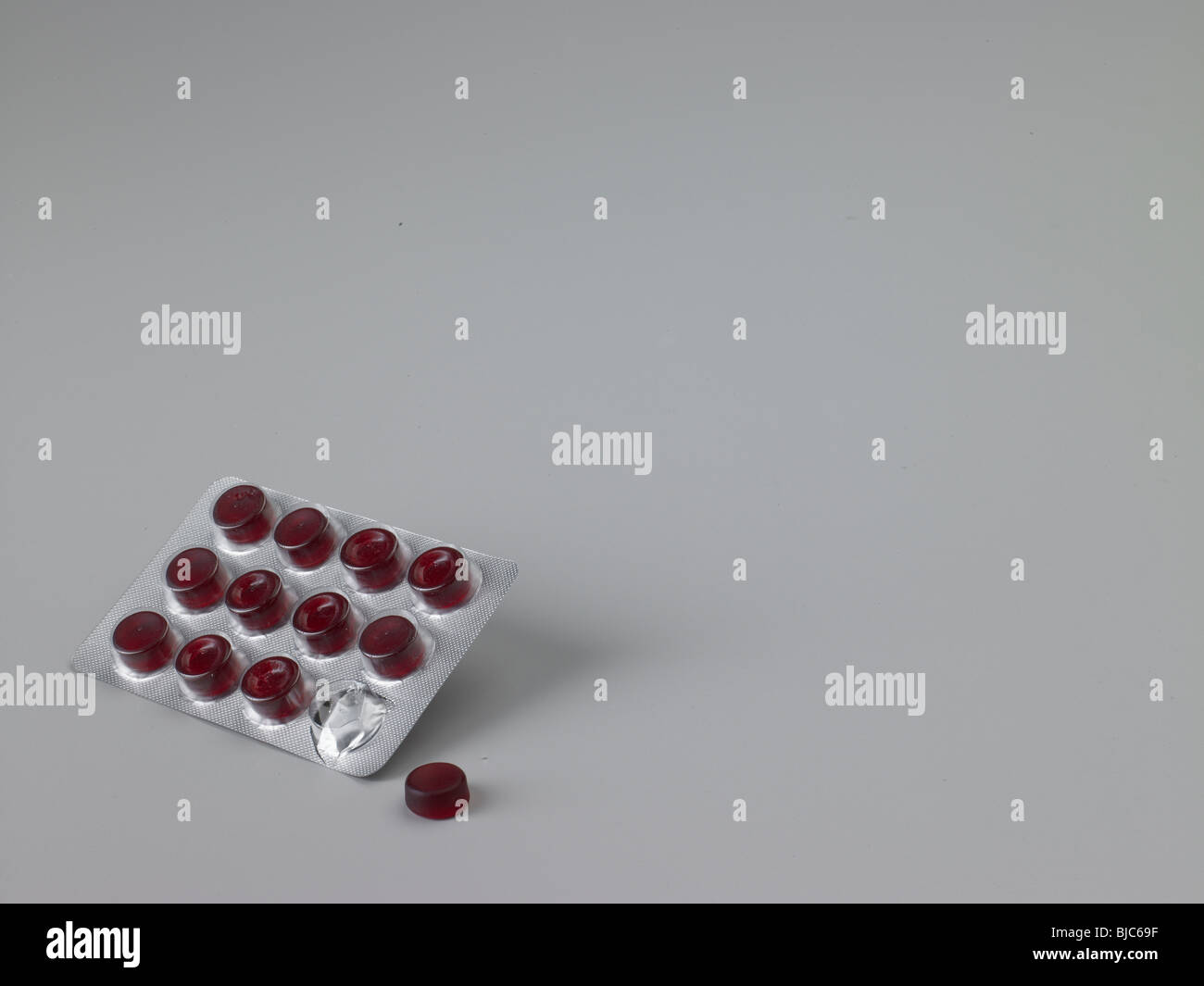 pharmaceutical tablets on grey background. Red tablets in blister pack ...