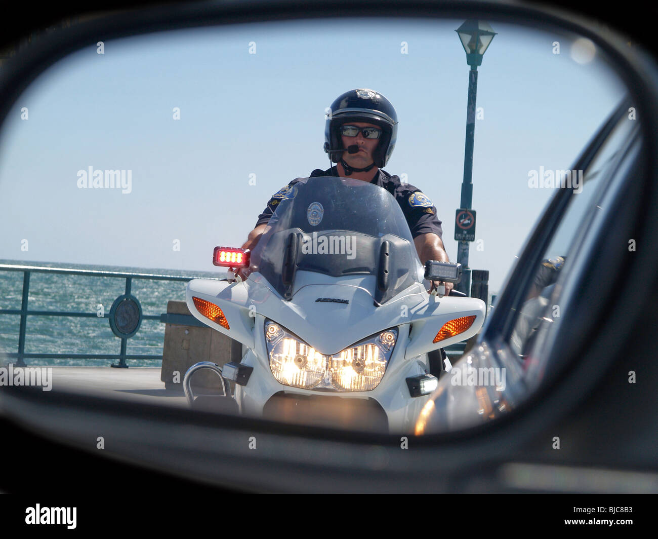 Motor patrol officer in rear view mirror Stock Photo - Alamy