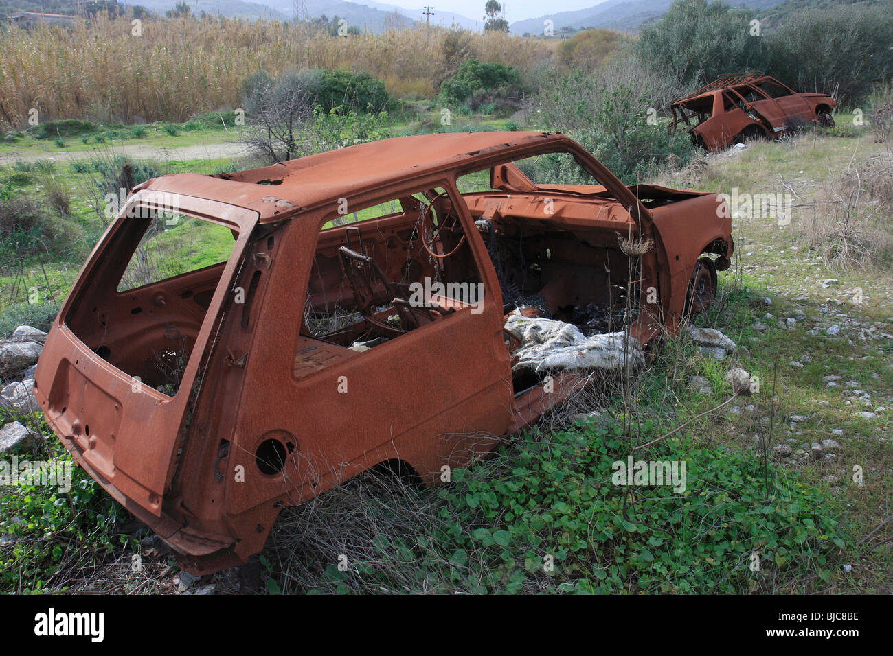 Burnt out and rusty car left at the roadside, Tirei, Italy Stock Photo ...