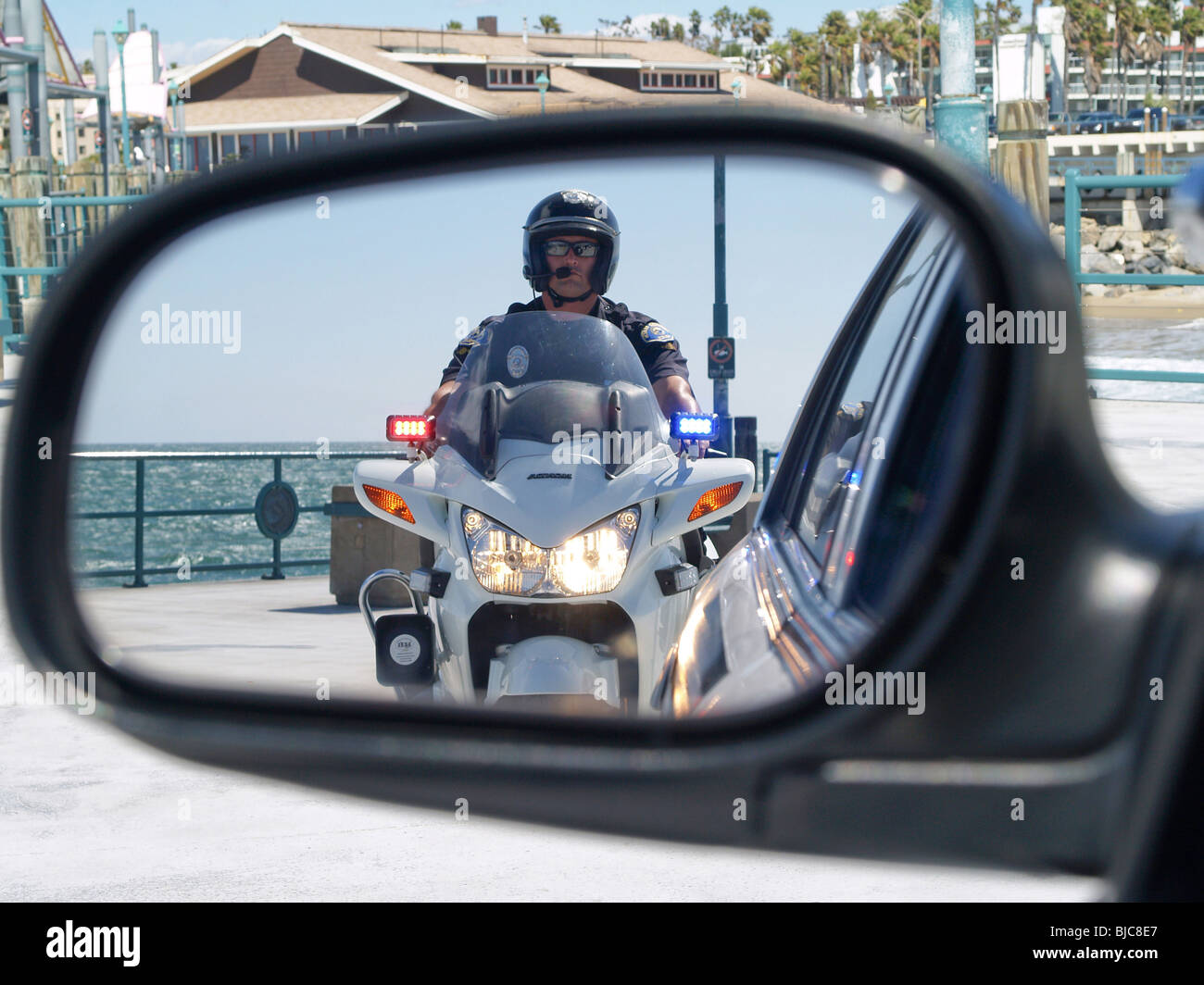 Motor patrol officer in rear view mirror Stock Photo - Alamy