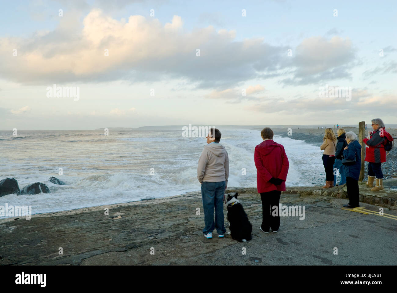 people on shore watching rough sea Stock Photo - Alamy