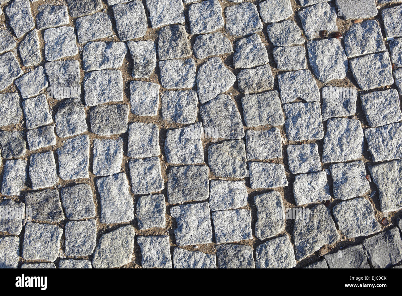 Grey cobblestone road as a textured background Stock Photo - Alamy